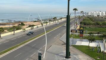 Uma estrada costeira com um letreiro do McDonald's, sinalização de estacionamento e uma passarela para pedestres.