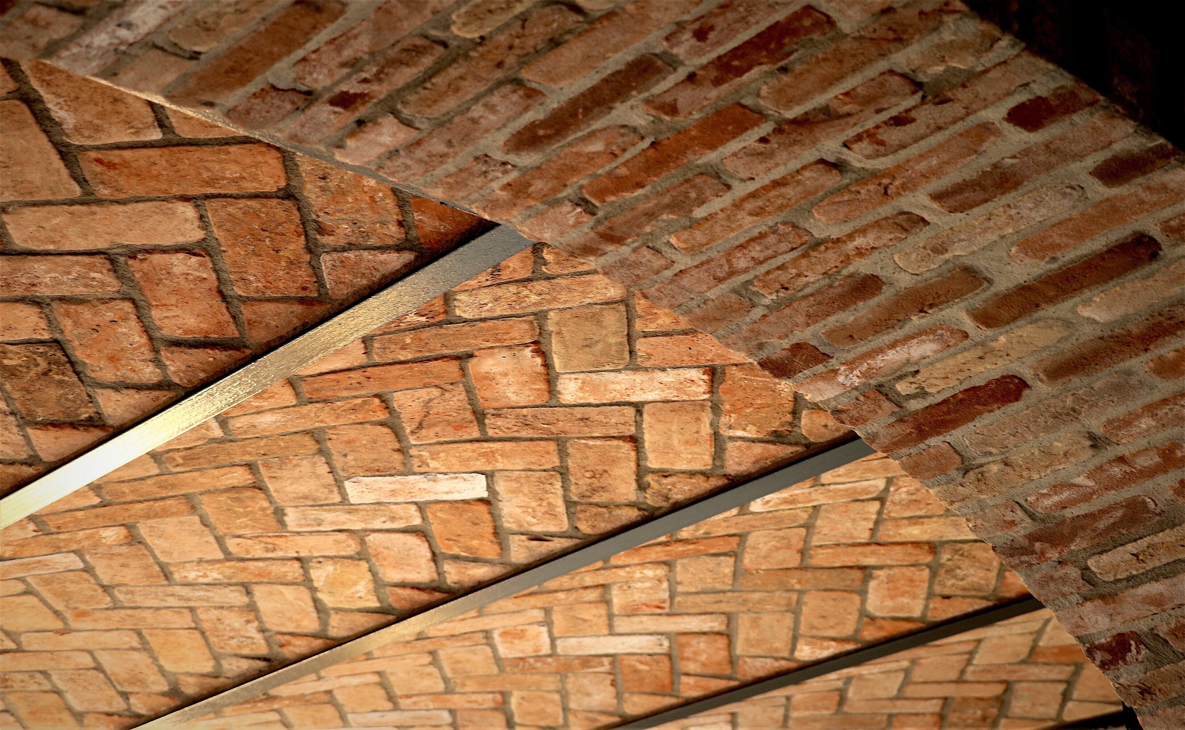 Um close-up de um chão de tijolos com padrão herringbone.