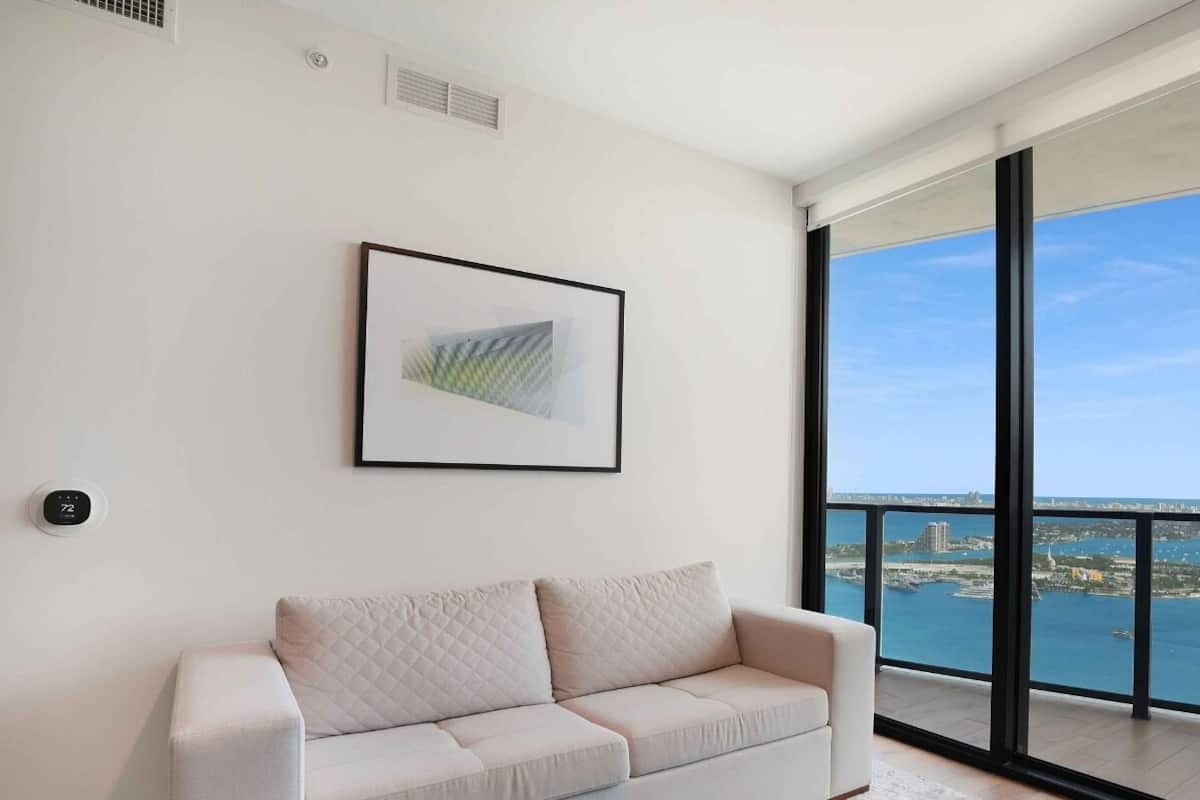 Apartamento Deluxe, 1 cama king-size e sofá-cama, vista para o oceano | Sala de estar | Smart TV de 55 polegadas com canais por cabo