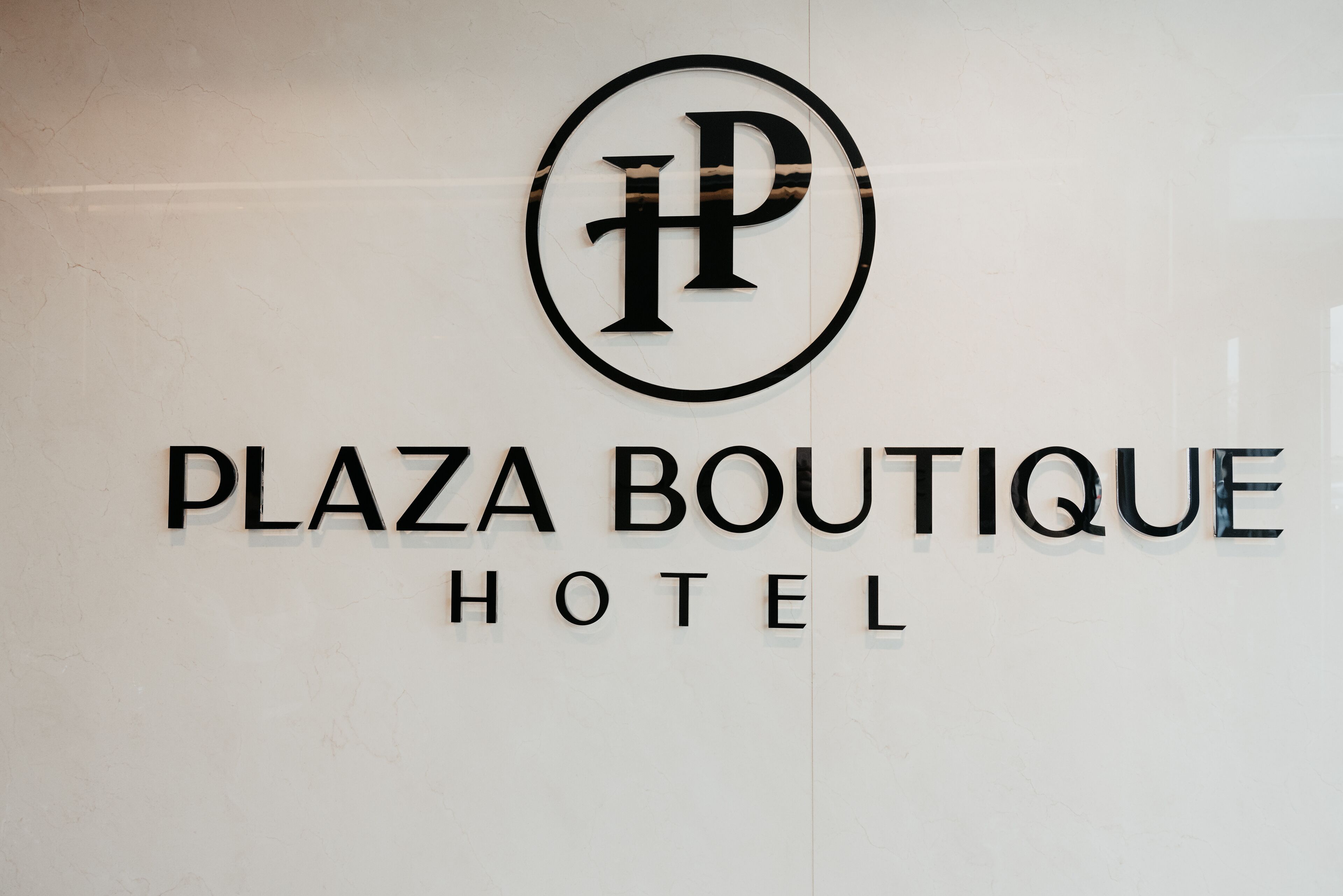 Placa do Plaza Boutique Hotel com um logotipo 'P' em destaque.