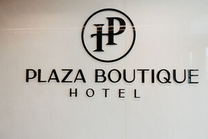 Placa do Plaza Boutique Hotel com um logotipo 'P' em destaque.