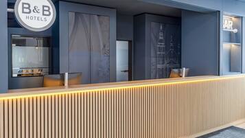 Uma receção com design moderno, exibindo o logótipo da B&B Hotels.