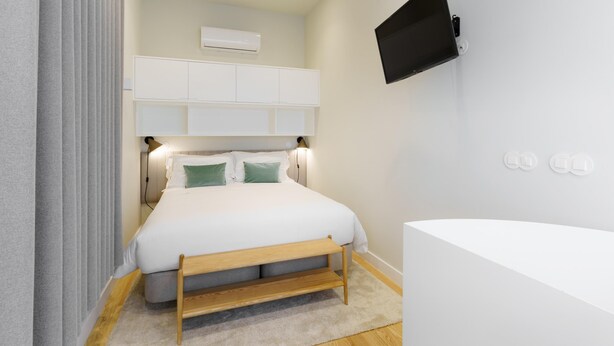 Quarto moderno com cama, mesas de cabeceira, televisão montada e ar condicionado integrado.