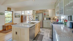 Uma cozinha espaçosa com bancadas de granito, eletrodomésticos de aço inoxidável e bastante espaço de armazenamento.