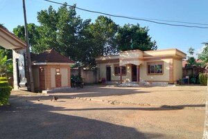 Área residencial com duas casas, um acesso pavimentado e uma motocicleta estacionada em frente a uma delas.