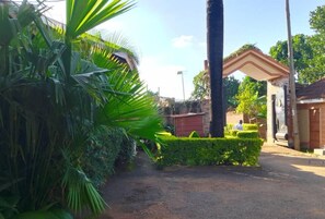 Uma trilha pavimentada que leva a um edifício com entrada coberta.