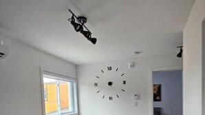 Uma sala de estar moderna com um relógio de parede grande, um sofá e piso de madeira.