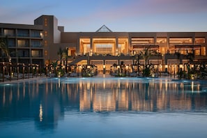 Hotel com uma piscina grande, vários andares e uma entrada imponente.