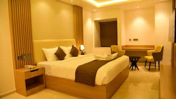 Quarto de hotel moderno com uma cama grande, mesas de cabeceira, uma escrivaninha e uma cadeira.