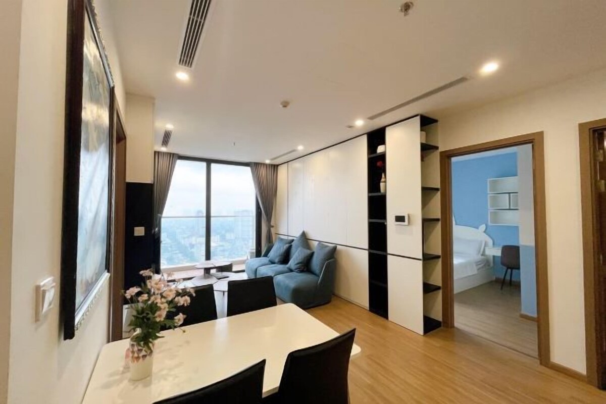 Uma sala de estar moderna com um sofá, uma mesa de jantar e vista para a cidade.