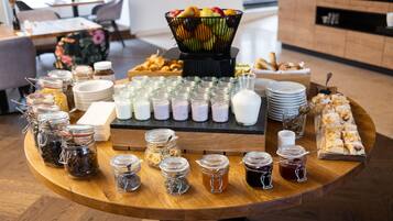 Um buffet de café da manhã com diversos alimentos e acompanhamentos.