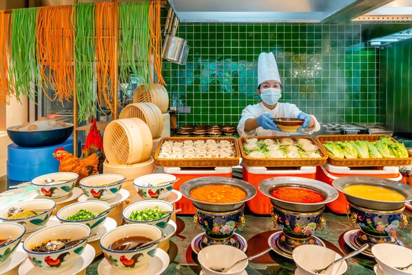 Disposição de buffet com diversos alimentos e utensílios de servir.