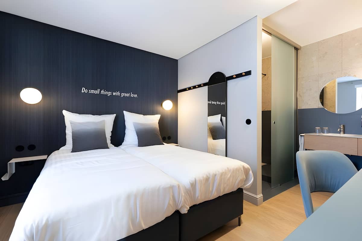Um quarto moderno com uma cama grande, mesas de cabeceira, um espelho e uma toucador com espelho.