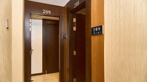 Um corredor de hotel com portas numeradas 209 e 208, mostrando os números dos quartos.