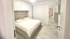 Quarto com cama, guarda-roupa embutido e espelho.