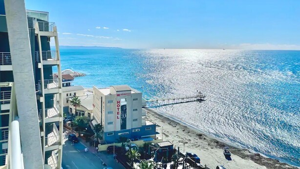Um hotel com vista para o mar, um cais e uma praia.