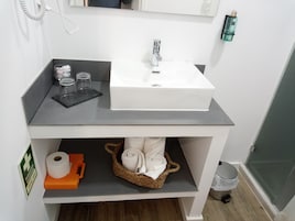 Quarto Twin Básico, 2 camas individuais | Casa de banho | Um polibã, um chuveiro fixo, um secador de cabelo, toalhas fornecidas