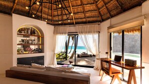 Quarto com uma cama grande, uma escrivaninha e vista para o oceano.