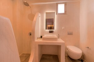 Uma casa de banho compacta com chuveiro, lavatório e sanita.