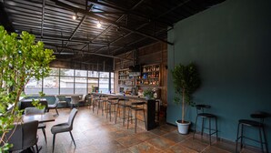 Uma área de bar moderna com assentos, balcão e uma grande janela com vista.
