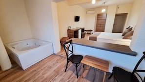 Uma casa de banho moderna com banheira, um banco de madeira e uma pequena mesa.