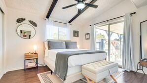 Quarto com cama, mesa de cabeceira e ventilador de teto.