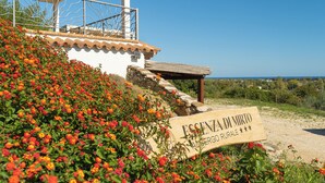 Um edifício rural com uma placa que diz "ESSENZA DI MIRTO ALBERGO RURALE".