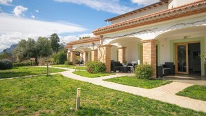 Uma villa com pátio, área de estar ao ar livre e jardim.