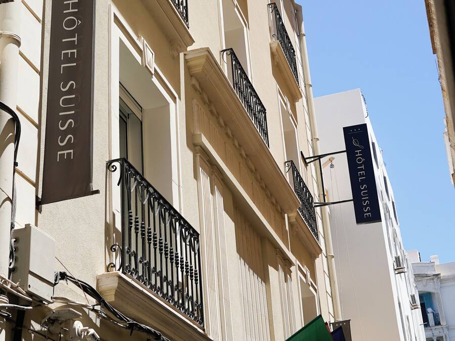 Um edifício com varandas, uma placa com a inscrição
