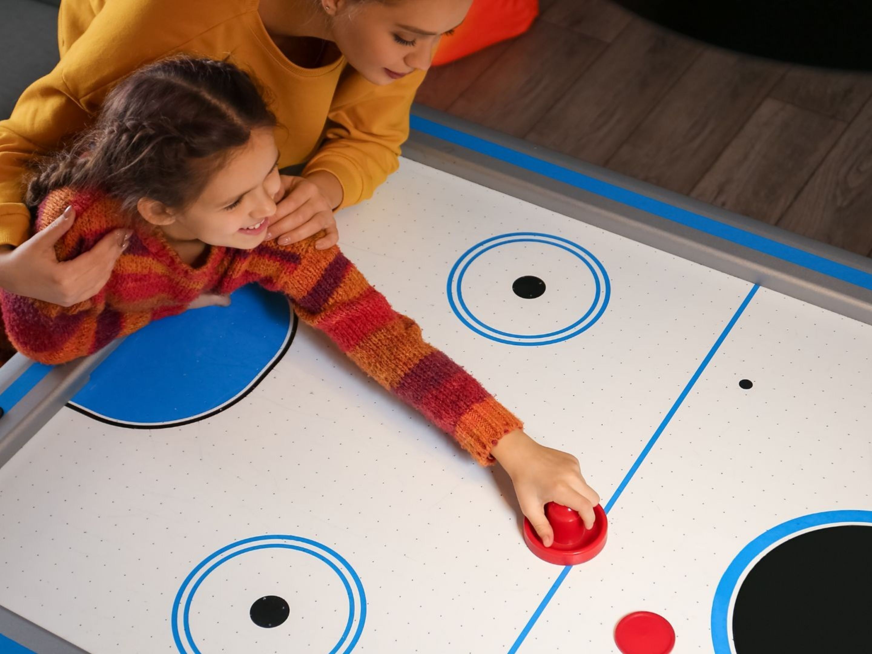 Criança brincando em um jogo de hóquei de mesa.