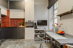 Apartamento Deluxe | Cozinha privada | Um frigorífico/congelador grande, um micro-ondas, um forno 