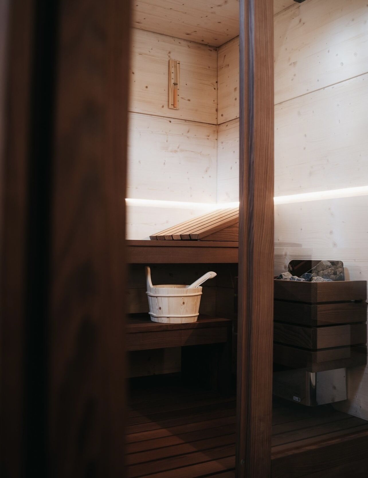 Uma sala de sauna com paredes de madeira e um banco.