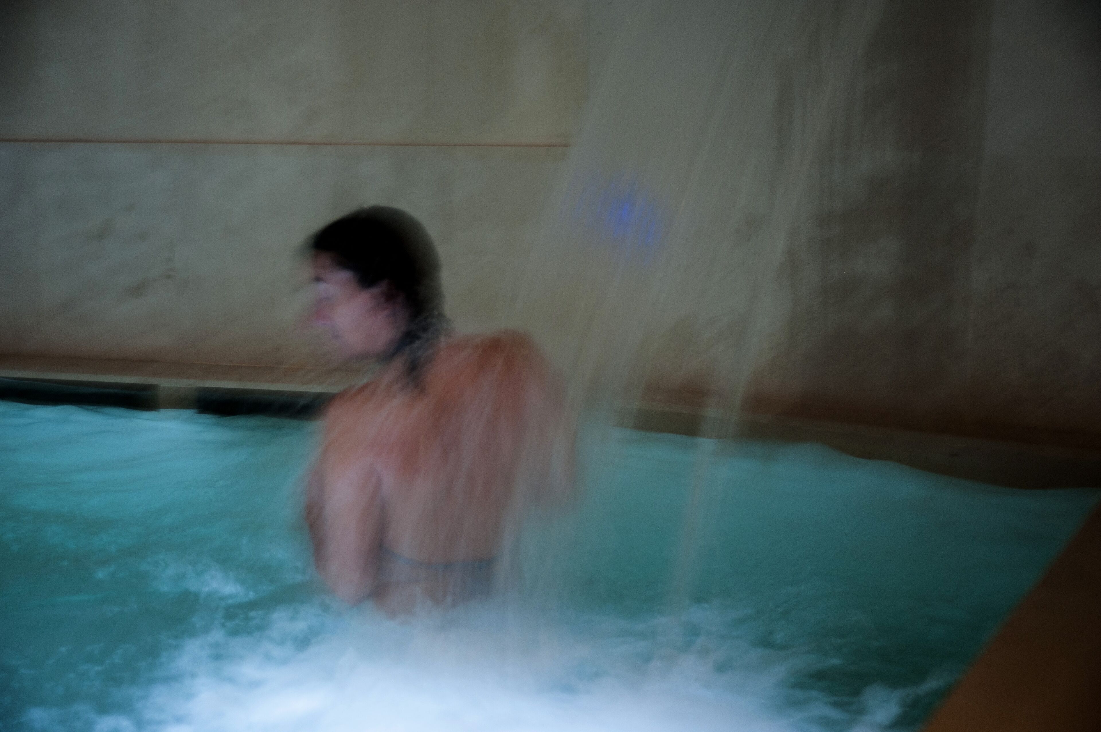 Uma pessoa em uma banheira de hidromassagem com jatos de água.