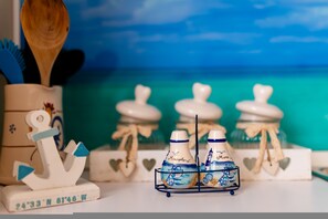 Decoração náutica com âncora, navio e potes com tampas em formato de coração.