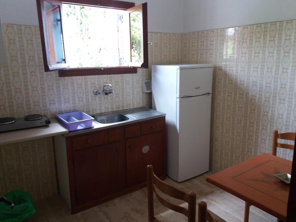 Uma cozinha compacta com geladeira, pia e janela.