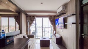 Uma sala de estar moderna com sofá, mesa de centro, televisão e varanda com vista.