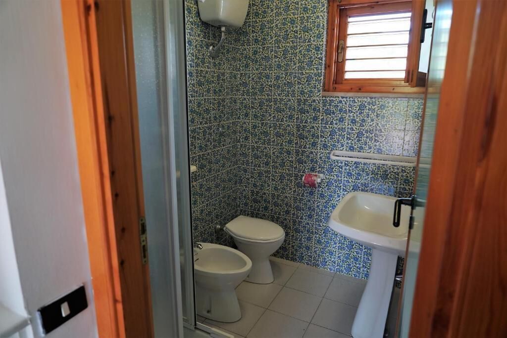 Casa de banho com duas sanitas, um bidé e lavatório.