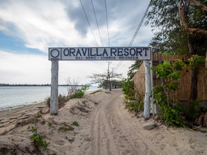 Na praia, areia branca, espreguiçadeiras, guarda-sóis 