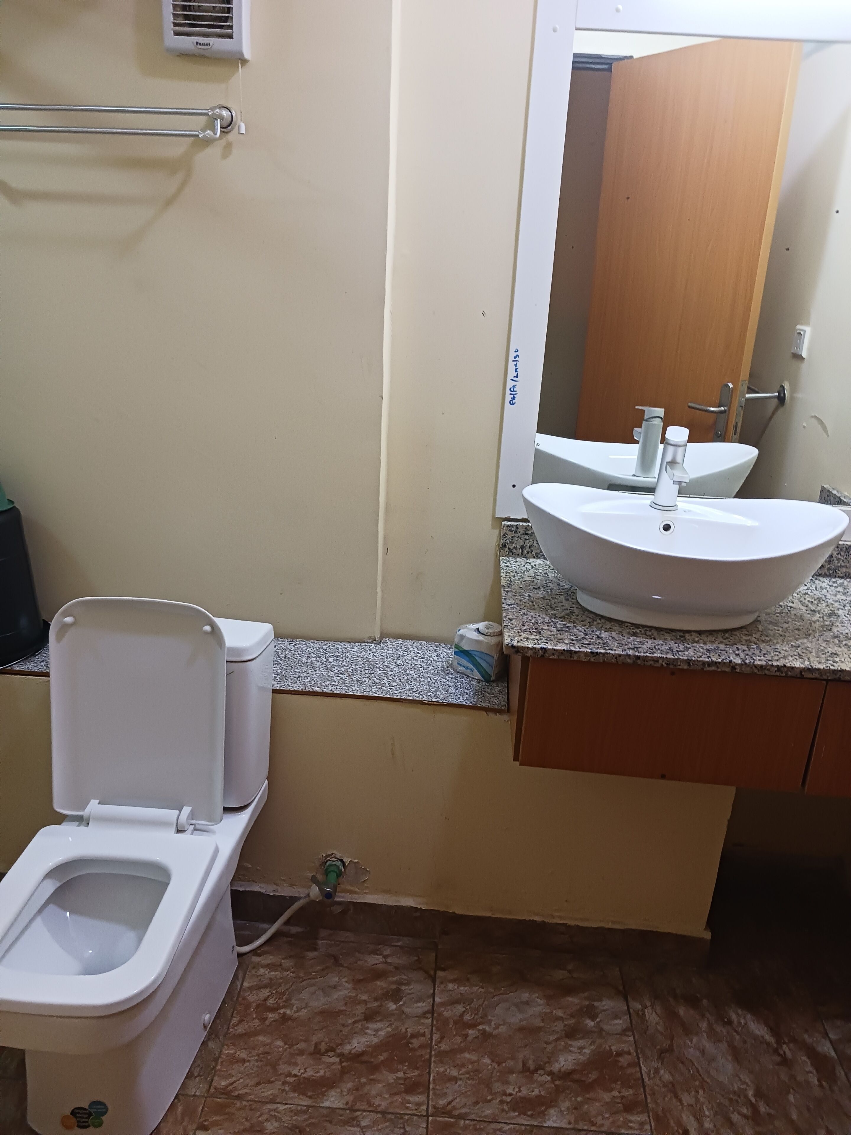 Casa de banho com sanita, lavatório e espelho.