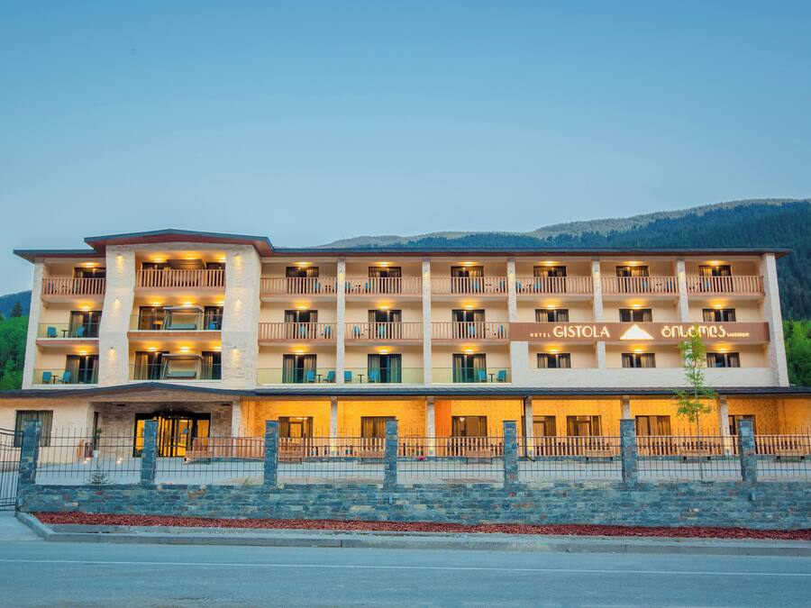 Um hotel de vários andares com varandas, fachada de pedra e uma placa com a inscrição "GISTOLA ONLAMES".