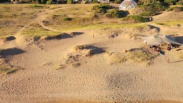 Na praia, guarda-sóis de praia, toalhas de praia, ioga
