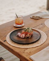 Uma mesa de madeira com um prato de comida e uma bebida.