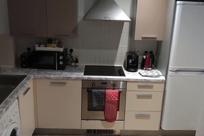 Um frigorífico, um micro-ondas, um forno, uma placa de cozinha