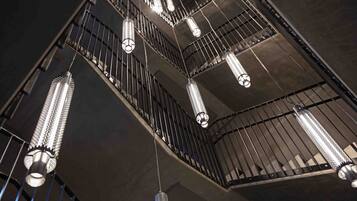 Um interior moderno com escada em espiral e luminárias pendentes.