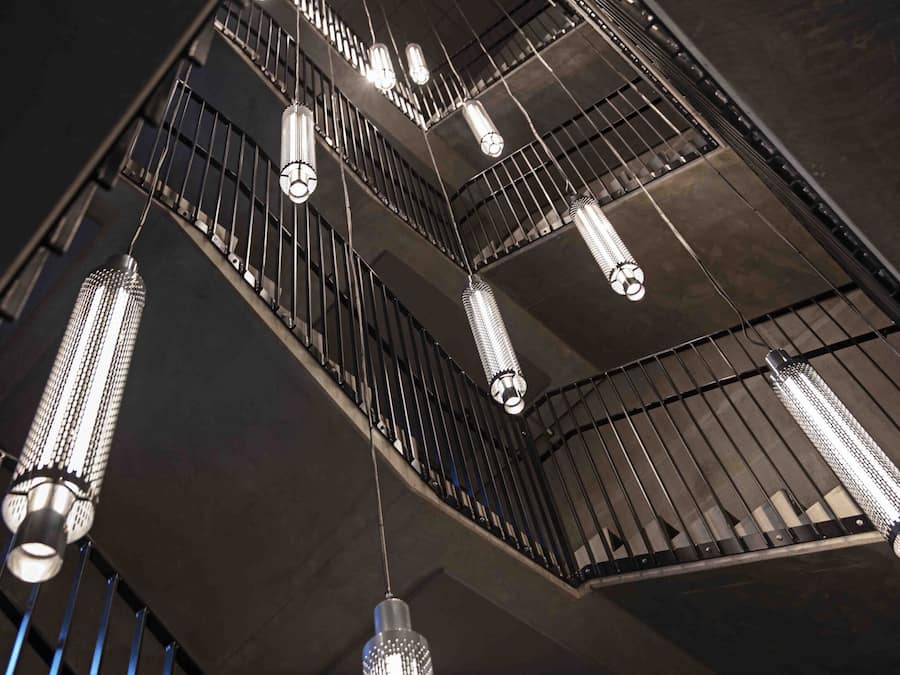 Um interior moderno com escada em espiral e luminárias pendentes.