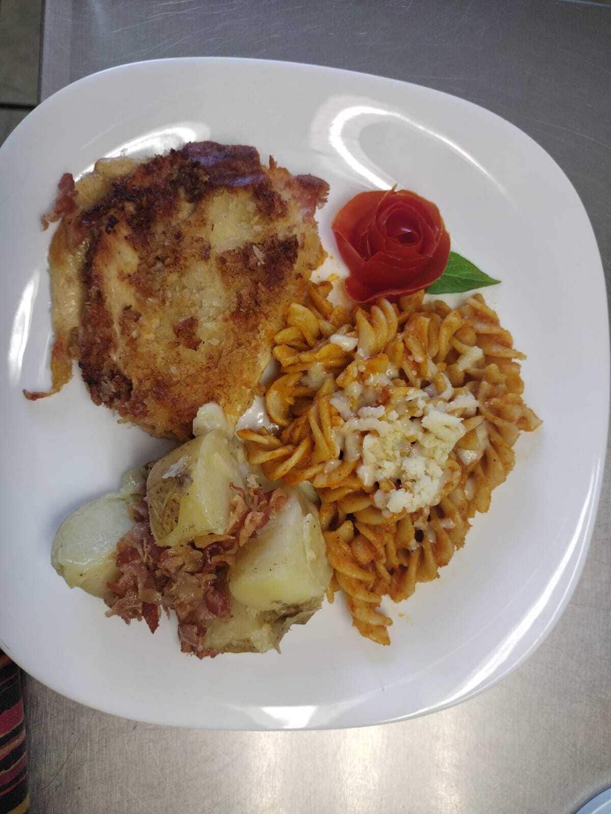 Um prato com escalope à milanesa, massa com queijo e batatas cozidas.