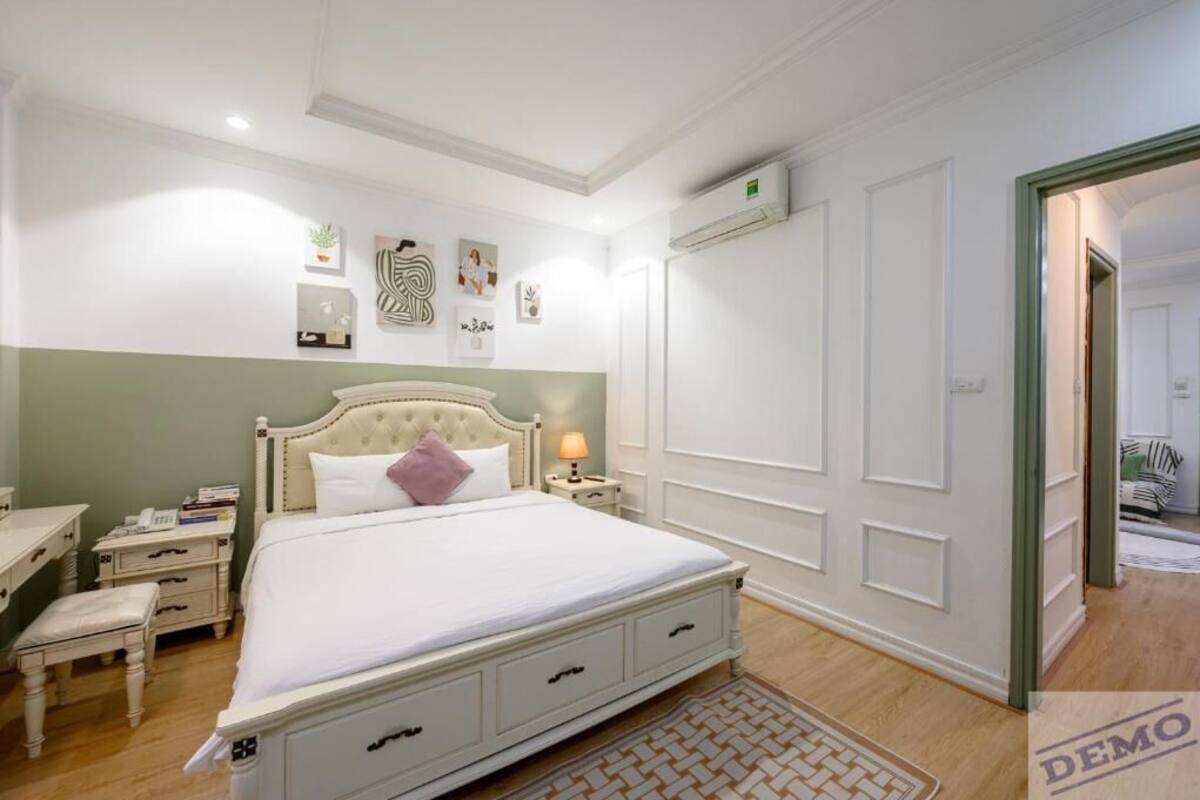 Um quarto bem organizado com cama, mesas de cabeceira, escrivaninha e uma cadeira.