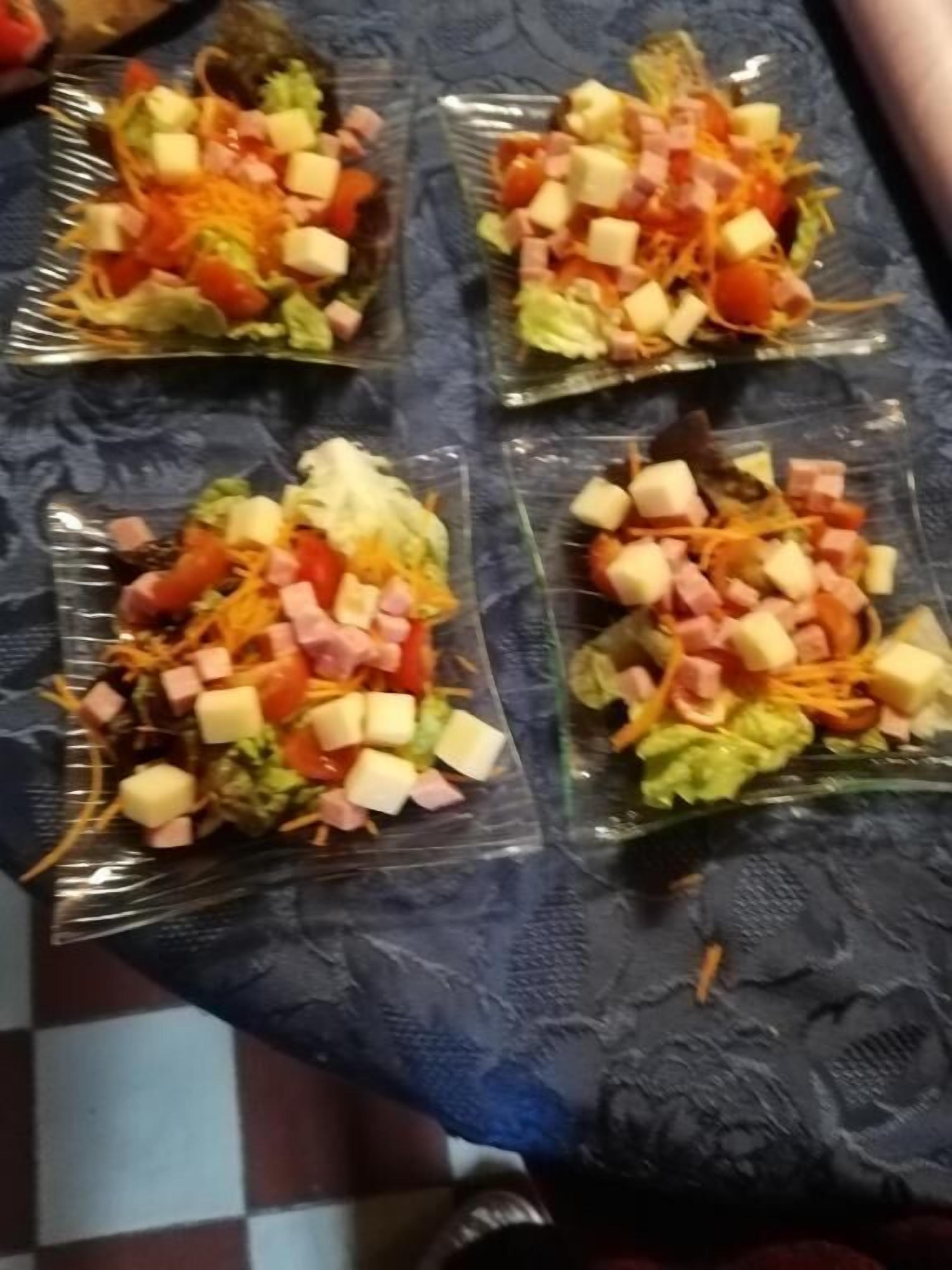 Quatro saladeiras sobre uma mesa com toalha quadriculada.