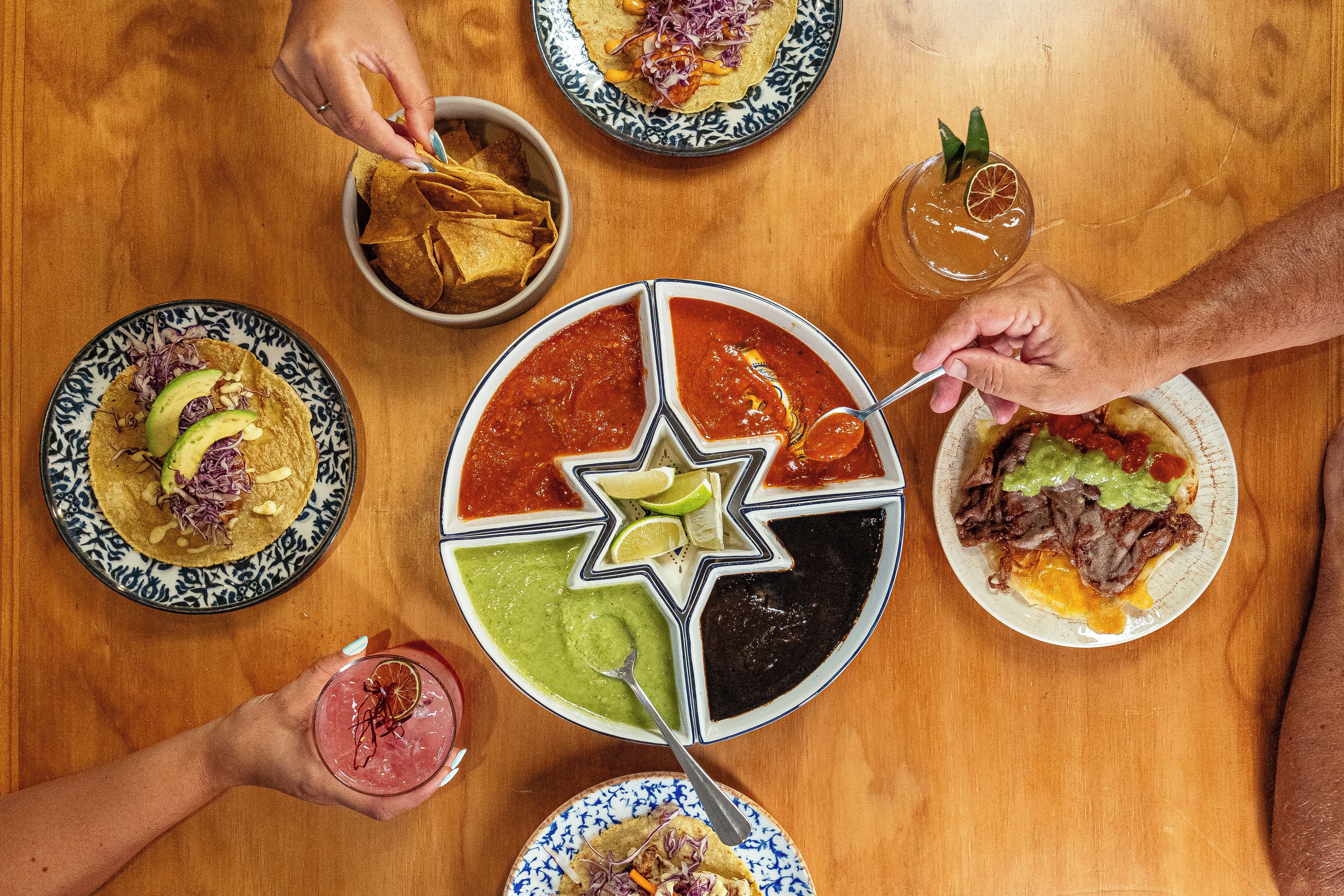Uma mesa com um prato em formato de estrela, dividido em quatro partes, cada uma com diferentes tipos de comida.