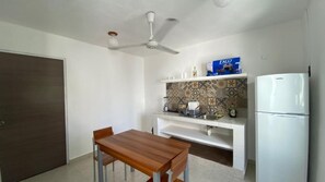 Geladeira grande, micro-ondas em uma área comum, liquidificador